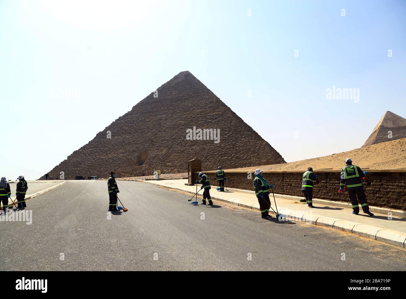 Beijing, Egypt. 25th Mar, 2020. Staff members clean near the Pyramids ...
