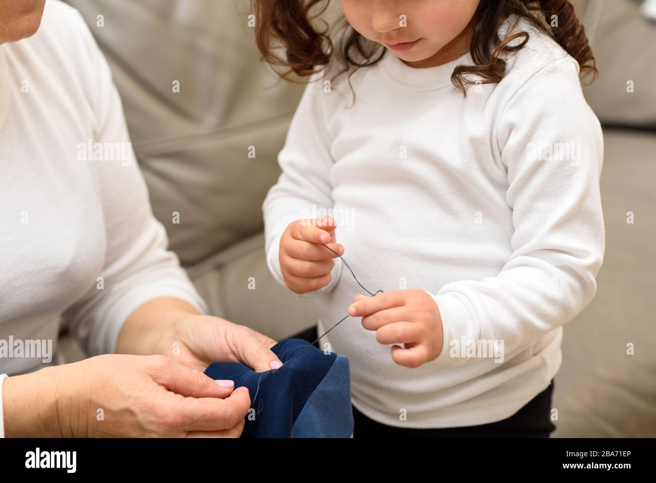 Grandmother Teaches Her Granddaughter To Mend Clothes. Kid Being ...