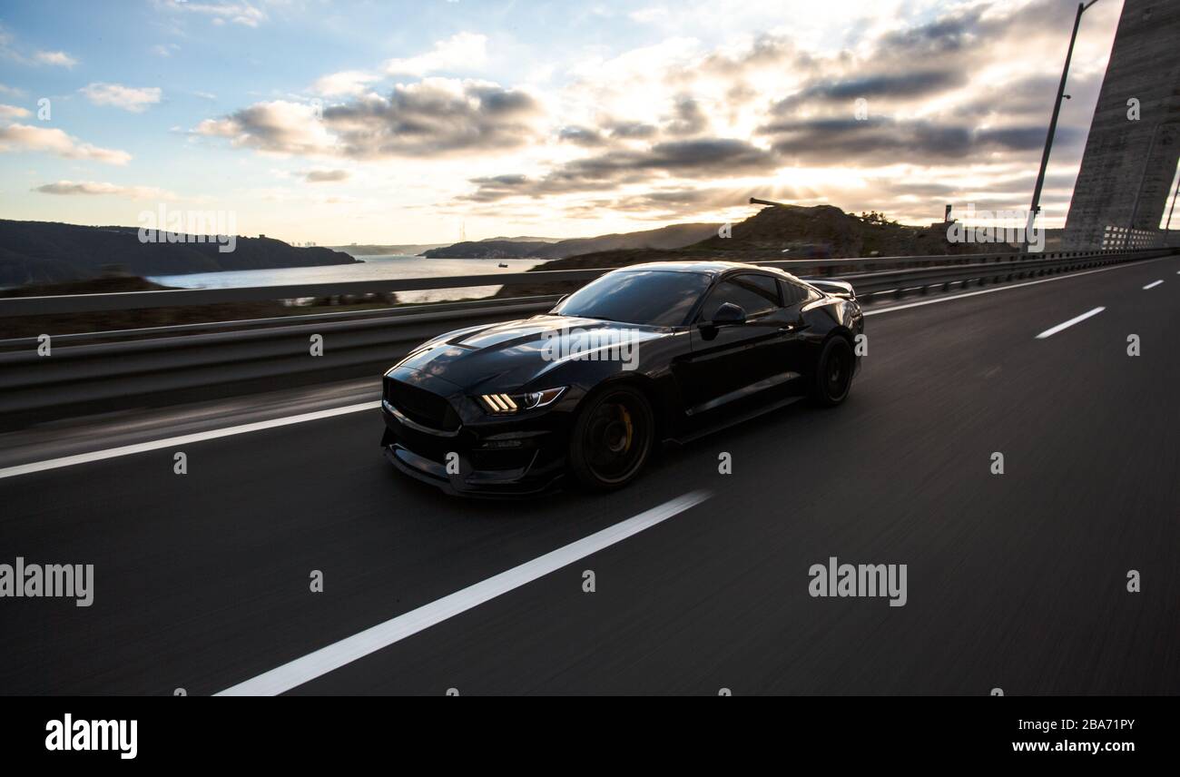 Black sport car driving on the road, front view Stock Photo - Alamy