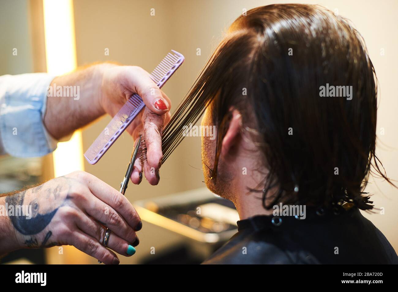 Close up photograph of hands cutting hair with scissors at a salon ...