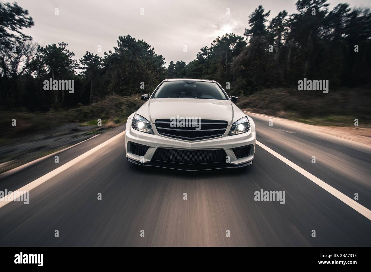 White sport sedan on the highway, front view Stock Photo - Alamy
