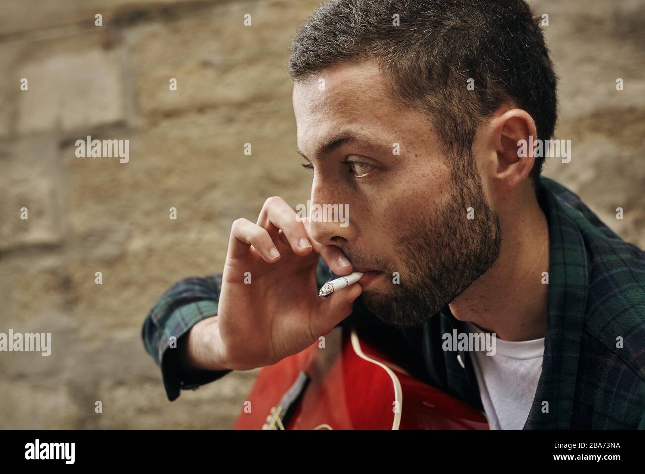 young guitarist playing guitar and smoking a cigarette Stock Photo - Alamy