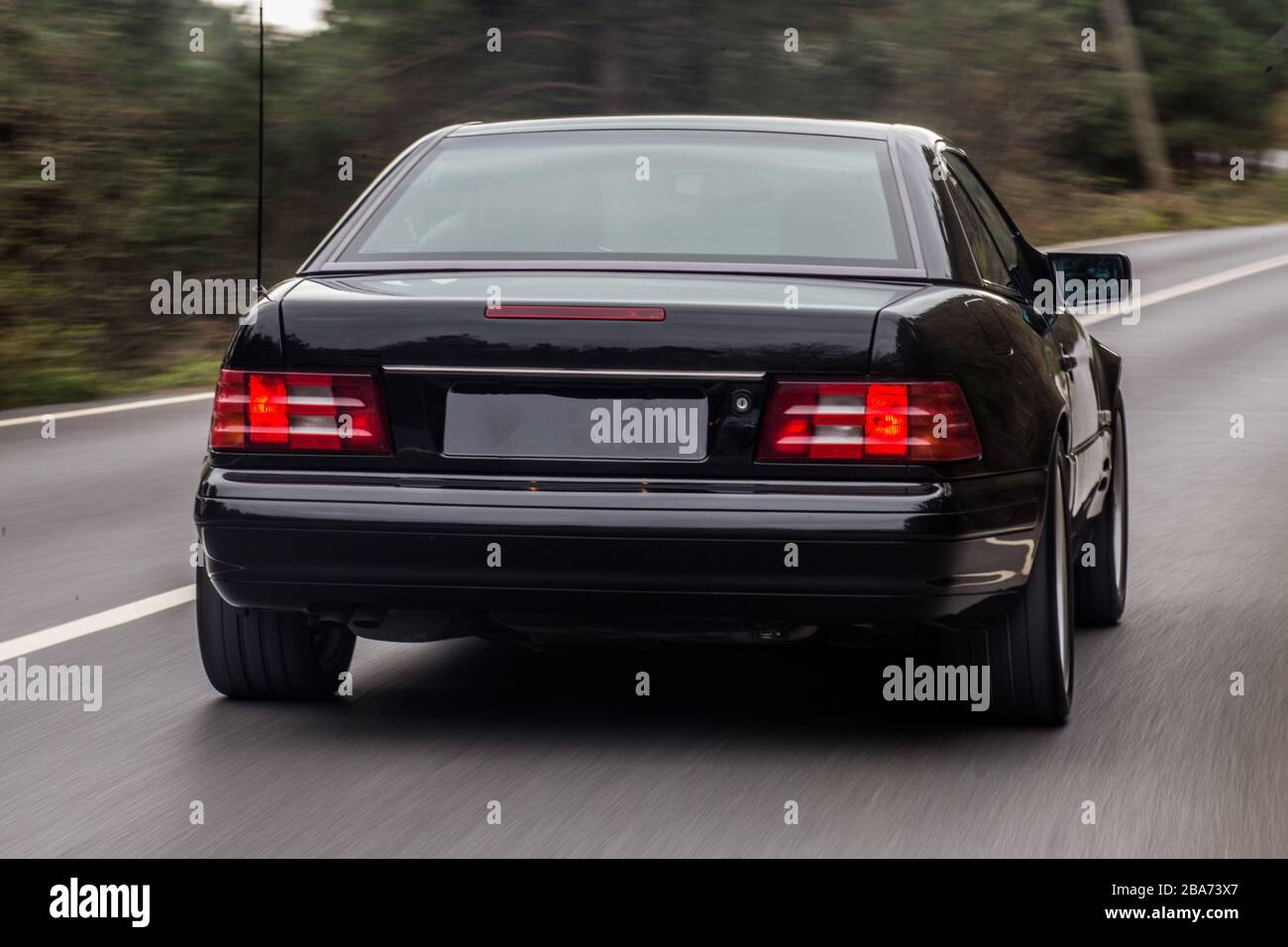 Black sedan on the highway, red lights on Stock Photo - Alamy