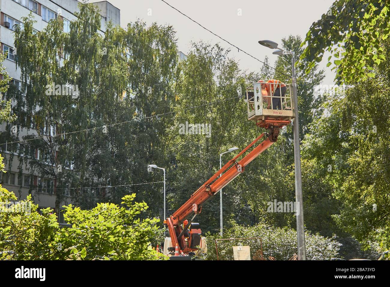 Saint Petersburg, RUSSIA - July 11, 2019: workers in lift bucket repair ...