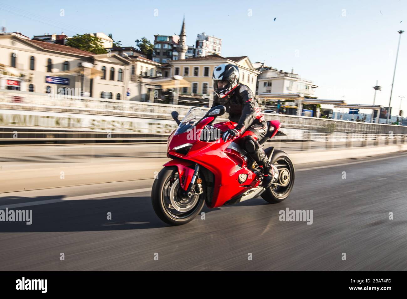 Driving a red motorcycle across properties Stock Photo - Alamy