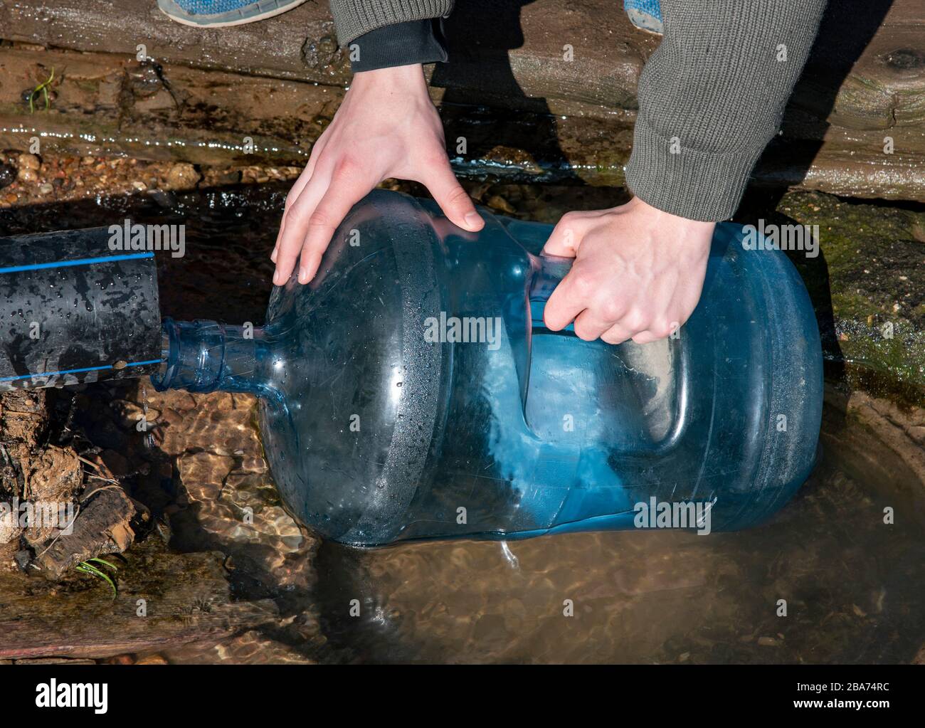 Men's hands fill a plastic bottle with water from a spring Stock Photo ...