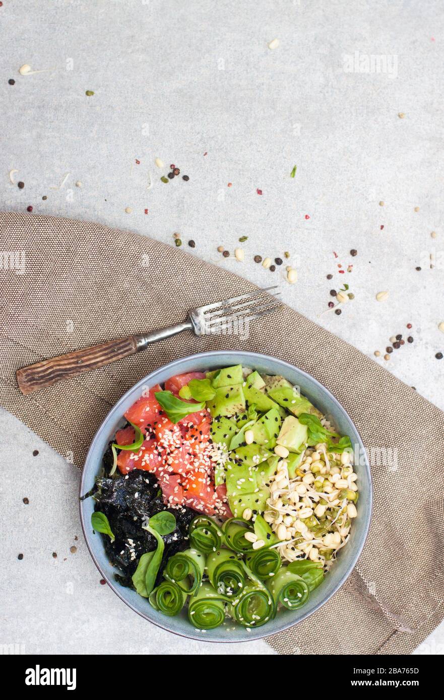 Salted salmon poke bowl with avocado, sea cale, cucumber, sesame seeds ...
