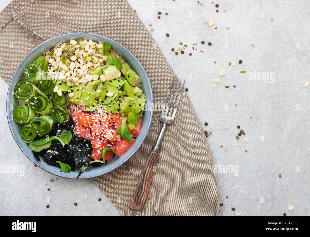 Salted salmon poke bowl with avocado, sea cale, cucumber, sesame seeds ...