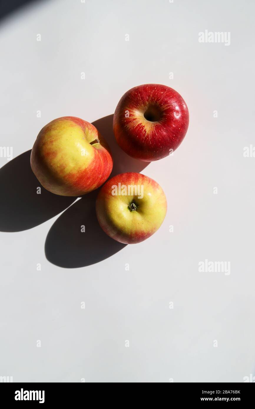 Fresh apples with strong shadow on white background at sunny day ...