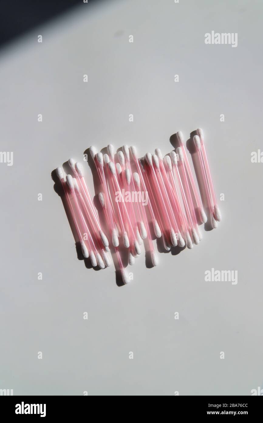 Pink cotton swab on white background with strong shadows. Minimal ...