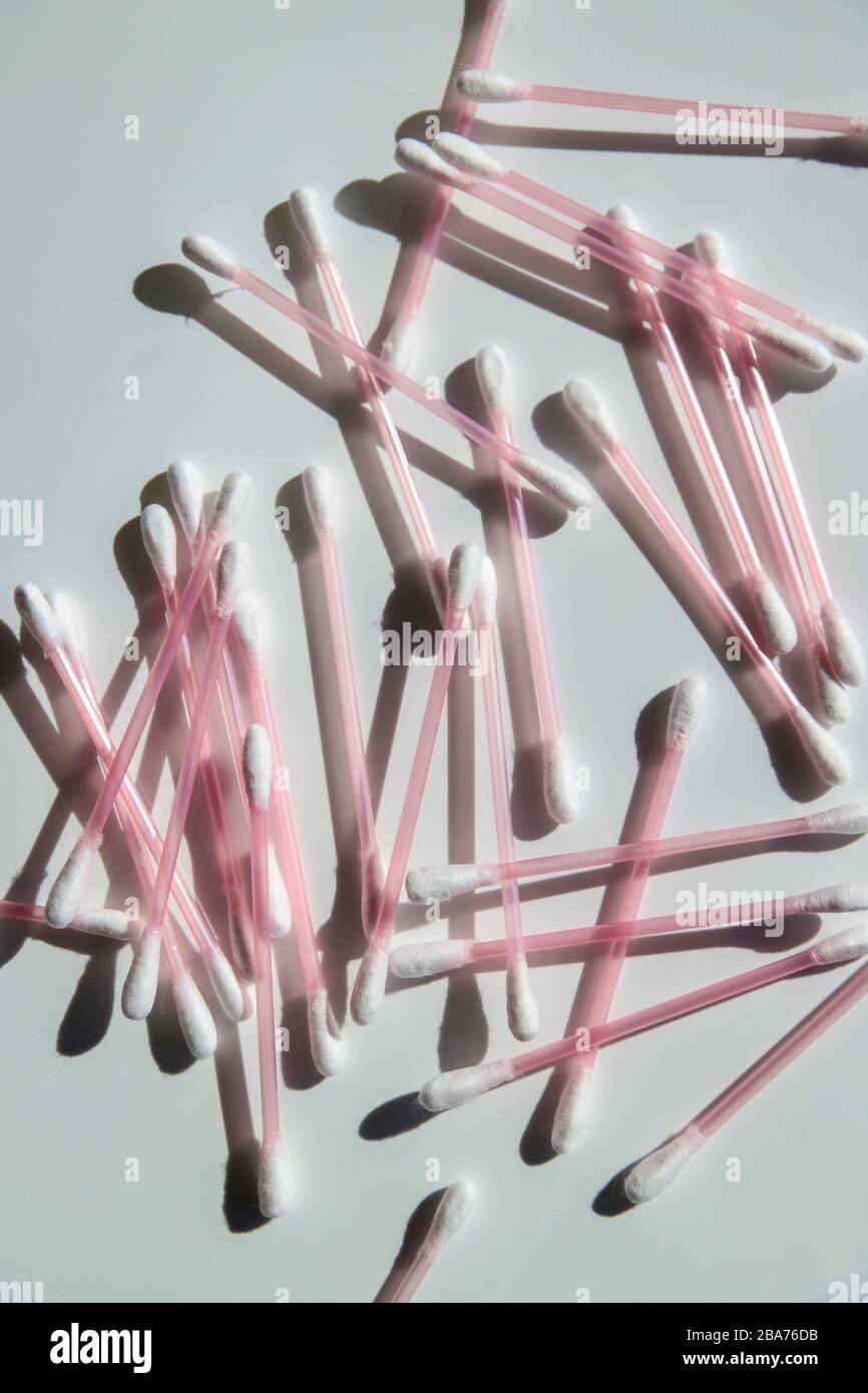 Pink cotton swab on white background with strong shadows. Minimal ...