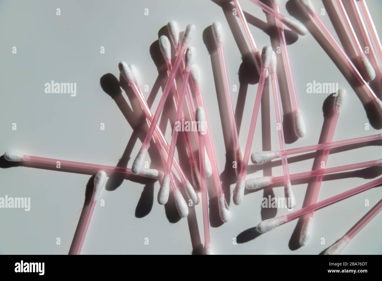 Pink cotton swab on white background with strong shadows. Minimal ...