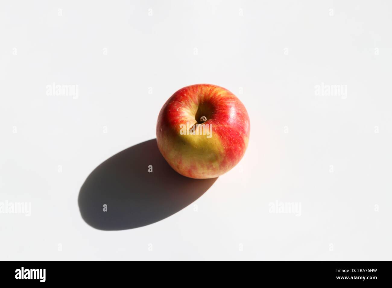Fresh apple with strong shadow on white background at sunny day. Trendy ...