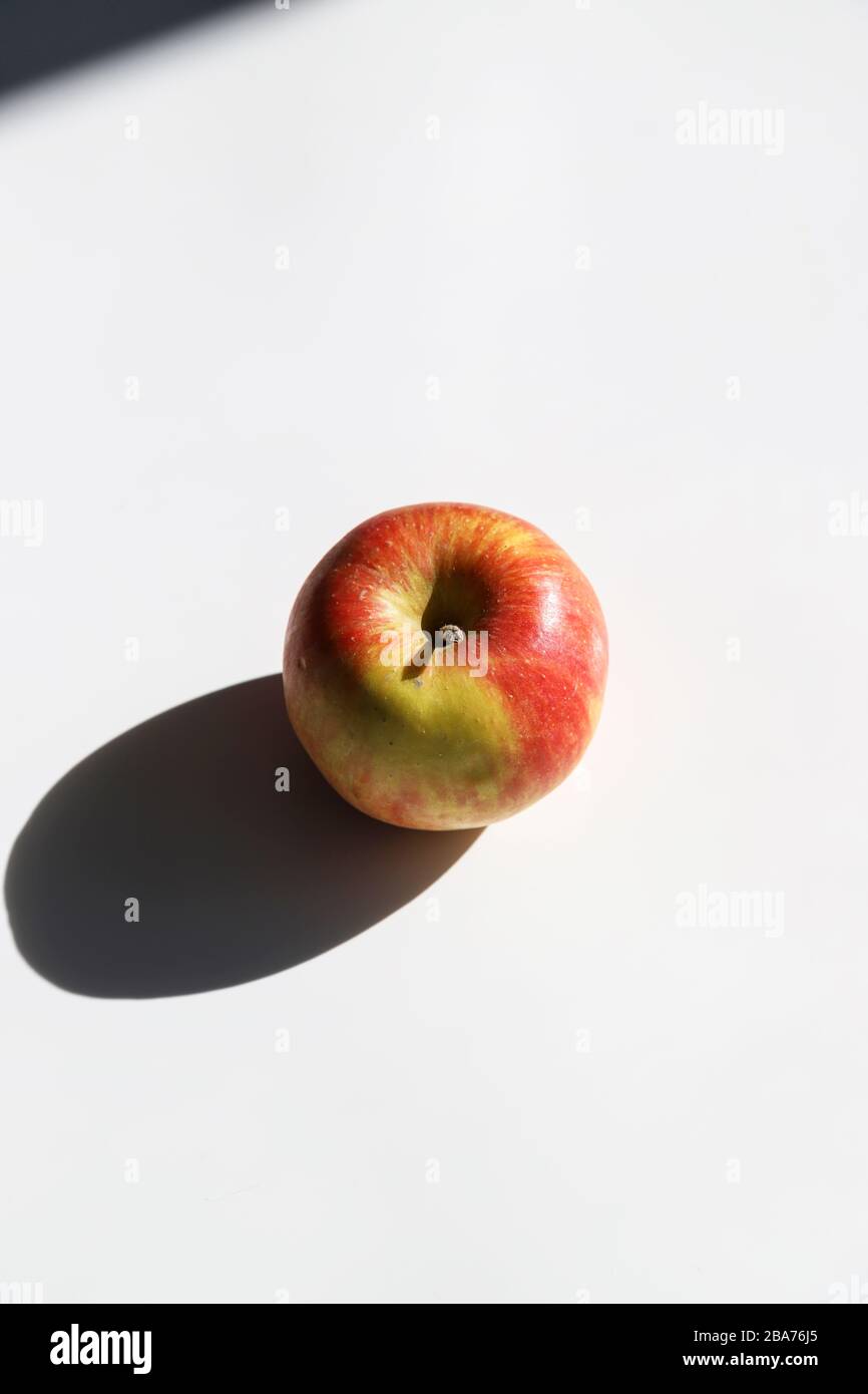 Fresh apple with strong shadow on white background at sunny day. Trendy ...