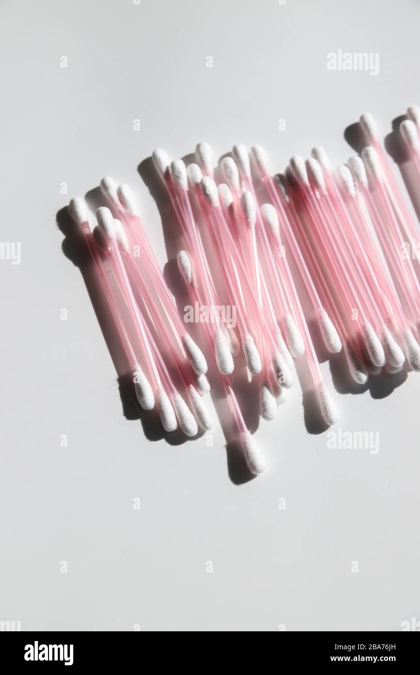 Pink cotton swab on white background with strong shadows. Minimal ...