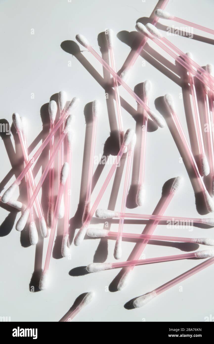 Pink cotton swab on white background with strong shadows. Minimal ...