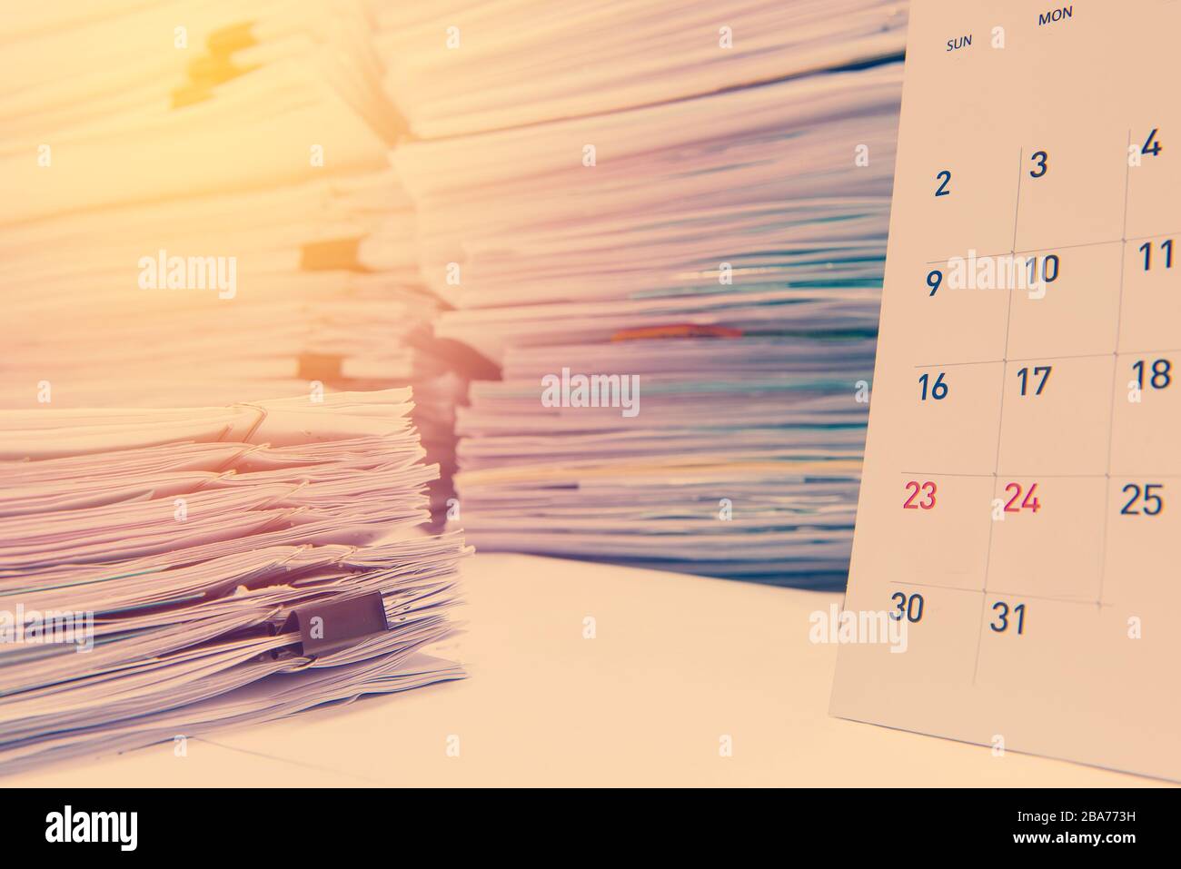 documents on desk stack up high waiting to be managed Stock Photo - Alamy