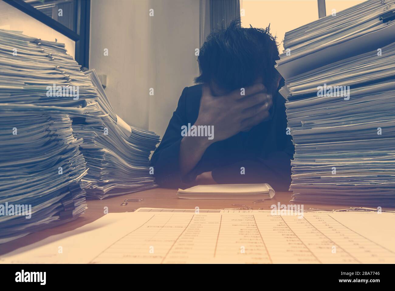 documents on desk stack up high waiting to be managed Stock Photo - Alamy