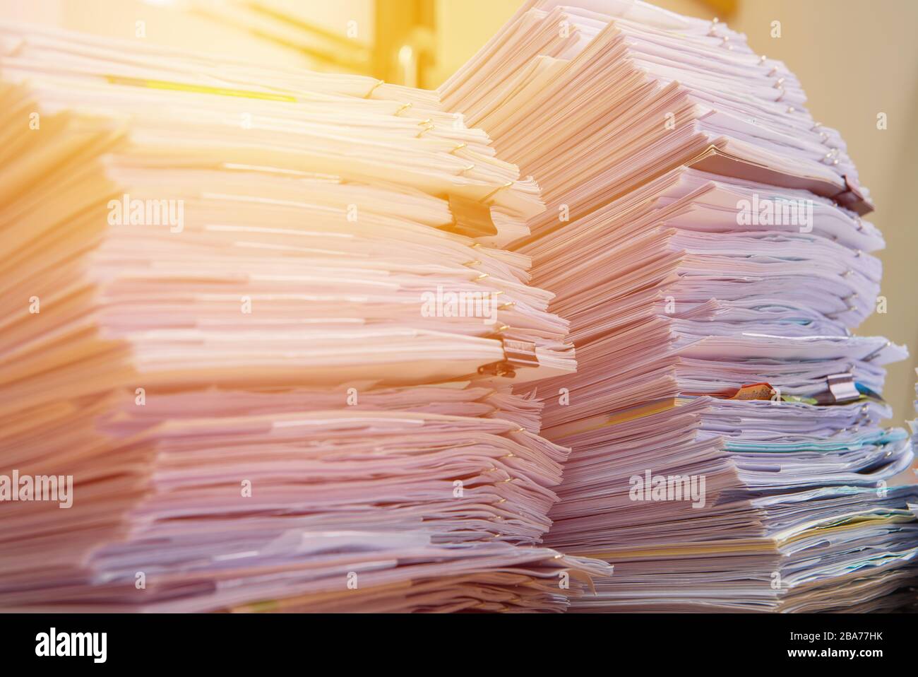 documents on desk stack up high waiting to be managed Stock Photo - Alamy