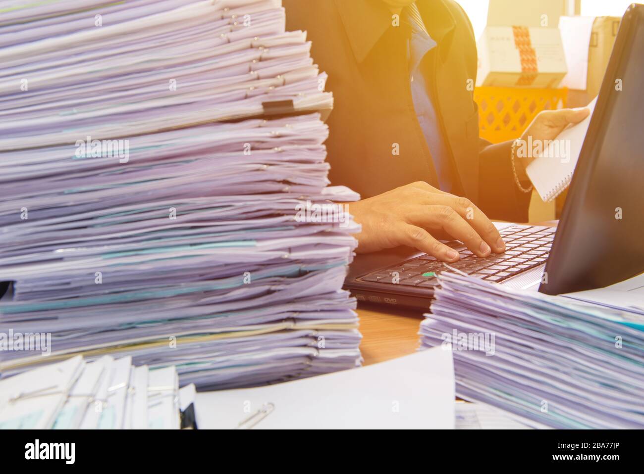 documents on desk stack up high waiting to be managed Stock Photo - Alamy