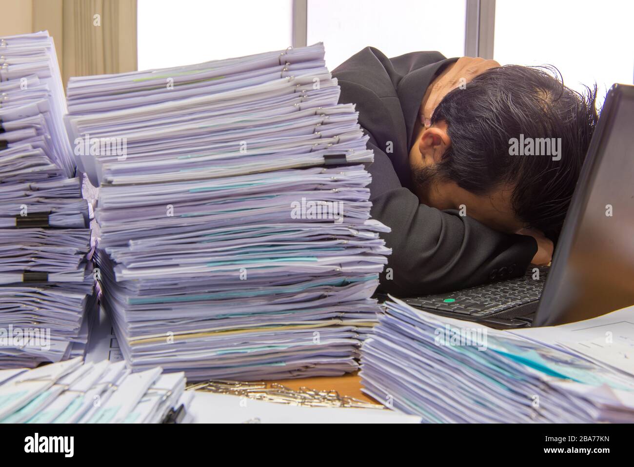documents on desk stack up high waiting to be managed Stock Photo - Alamy