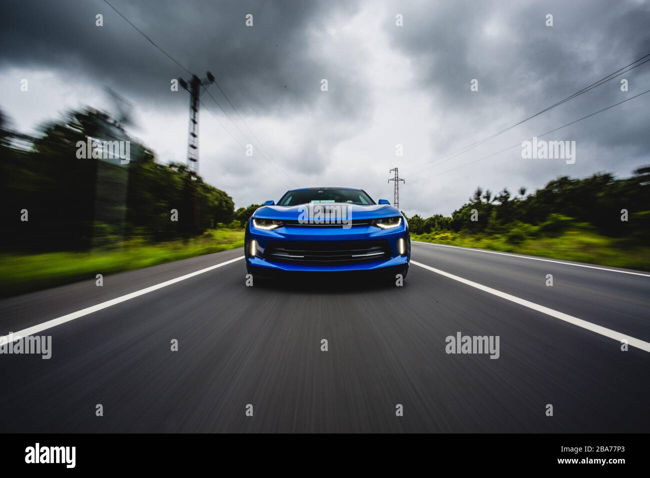 Blue sport car driving in the countryside Stock Photo - Alamy