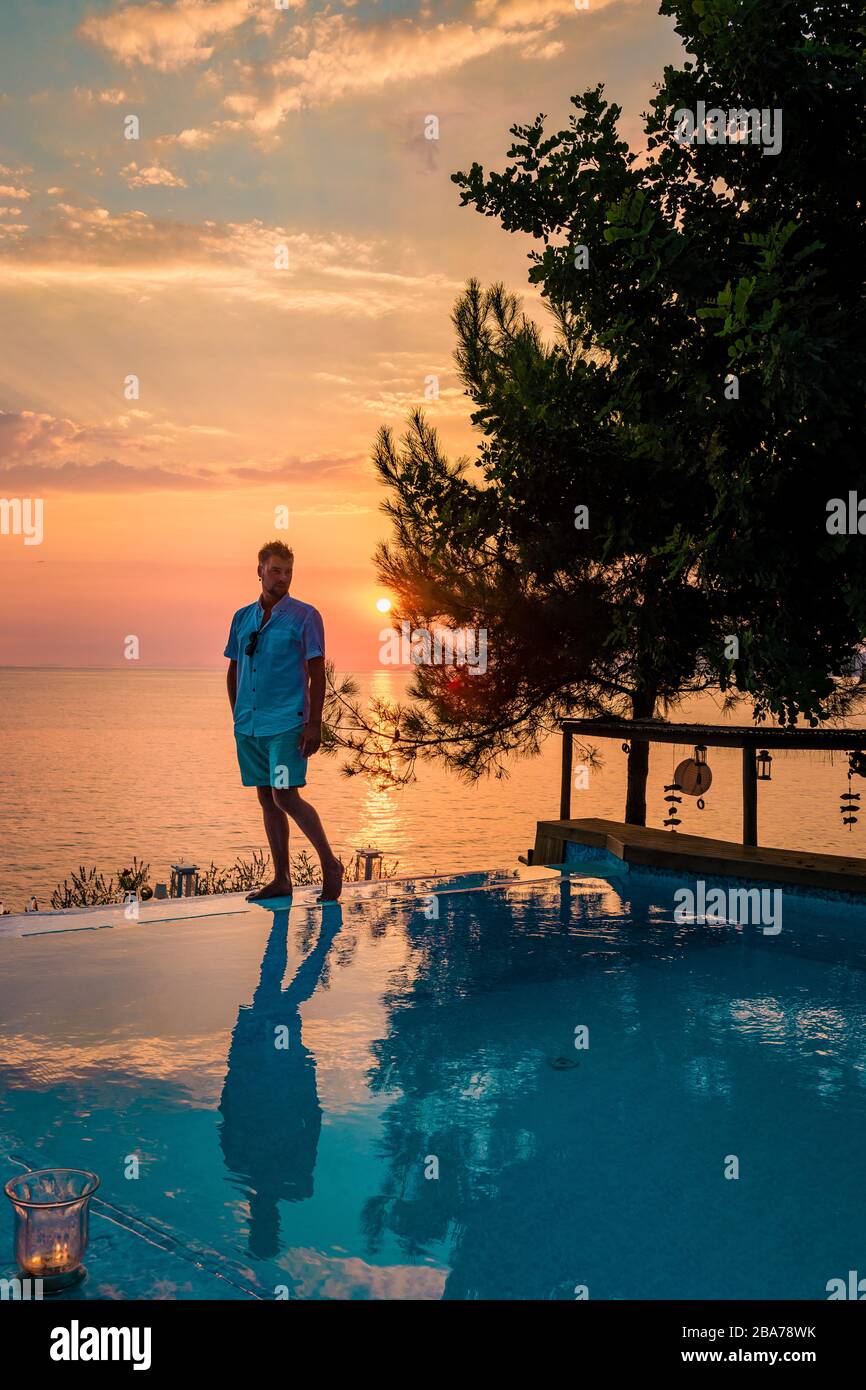 Fethiye Turkey, young guy in swim short watching sunset by the pool ...