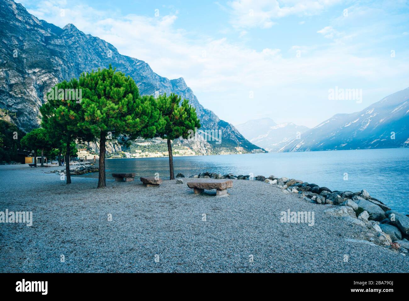 Green trees on the shore of valley of beautiful lake Garda among the ...