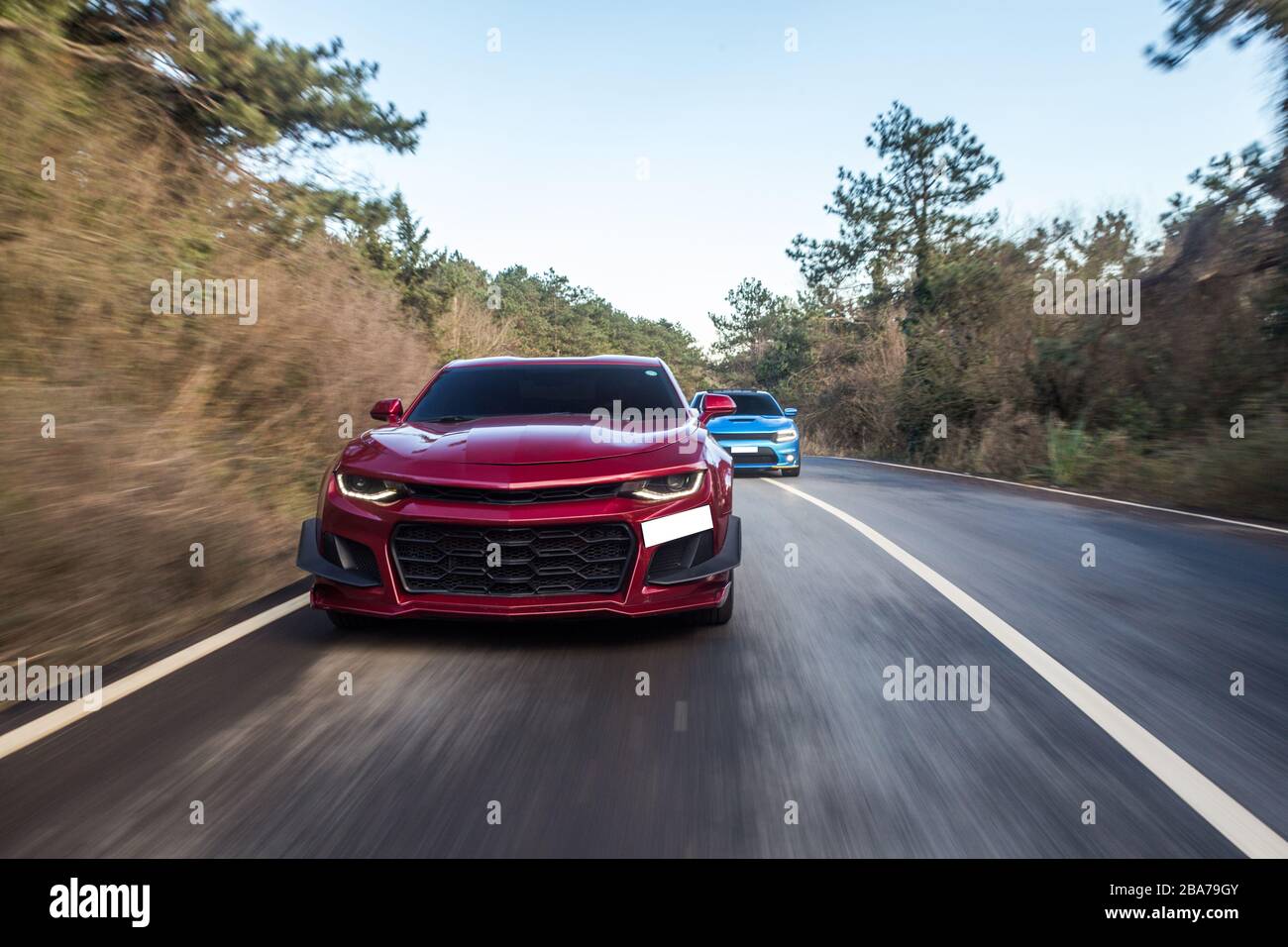 Red luxury business class sedan high speed drive.A blue car behind ...