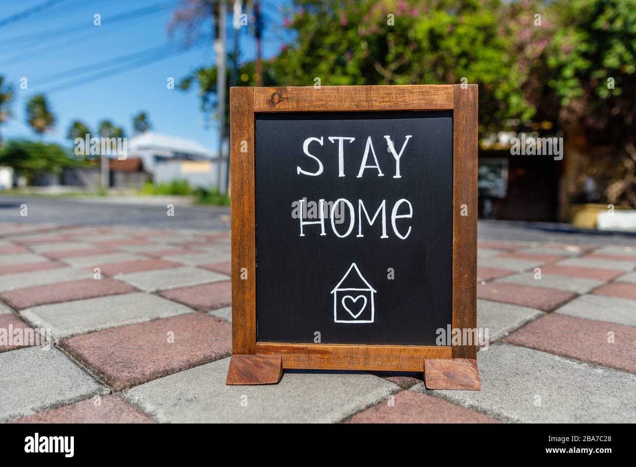 Black board sign STAY HOME standing in the empty street Stock Photo - Alamy