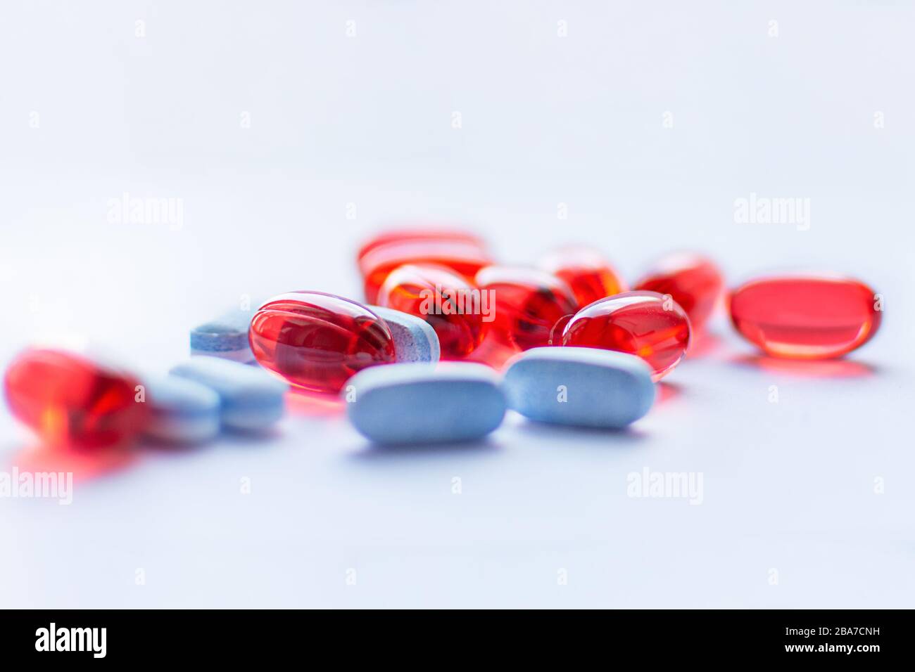 Red and blue capsules on white background. Pharmacy concept ...