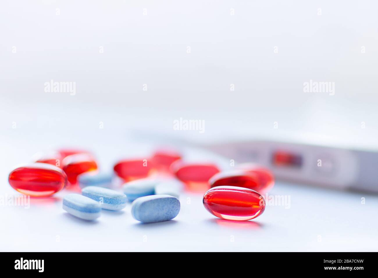 Red and blue capsules on white background. Pharmacy concept ...