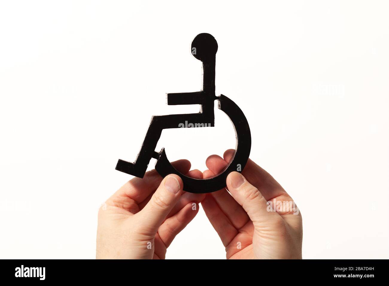 Hands holding a disabled cutout shape on a white background. Health ...