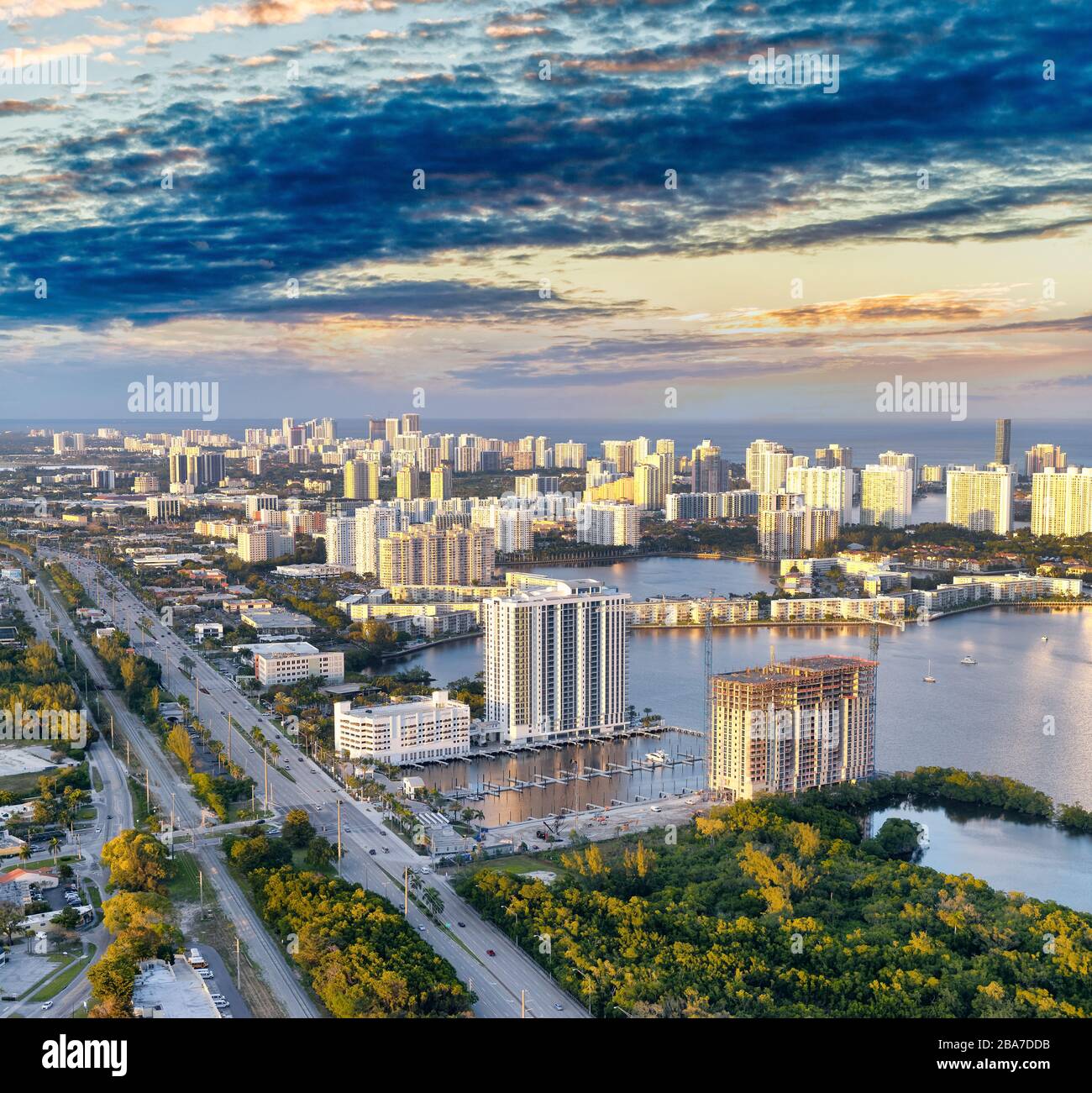 Sunset aerial view of Miami skyline from helicopter. Buildings, water ...