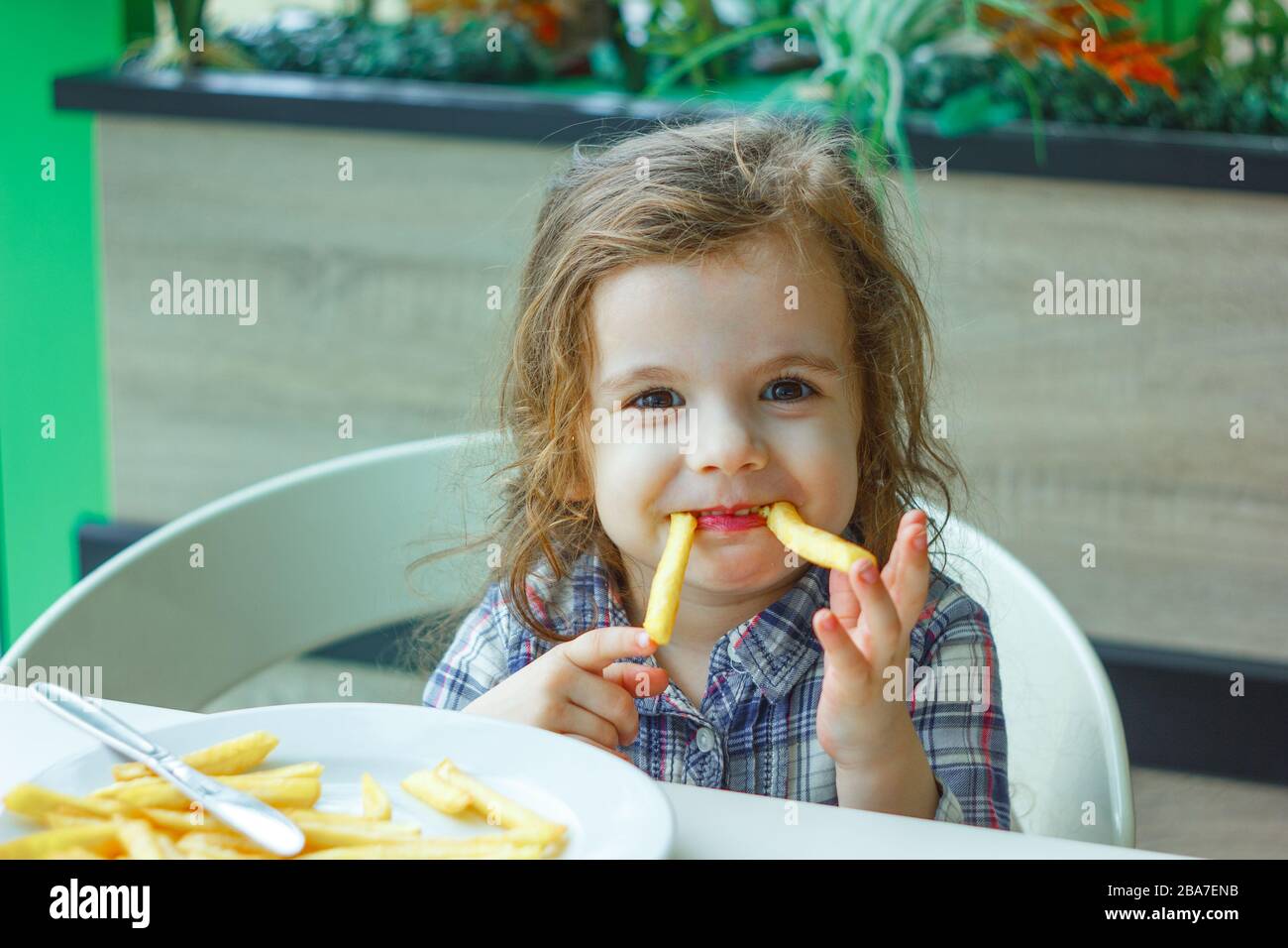 Little girl play with the french fries in a restaurant Stock Photo - Alamy