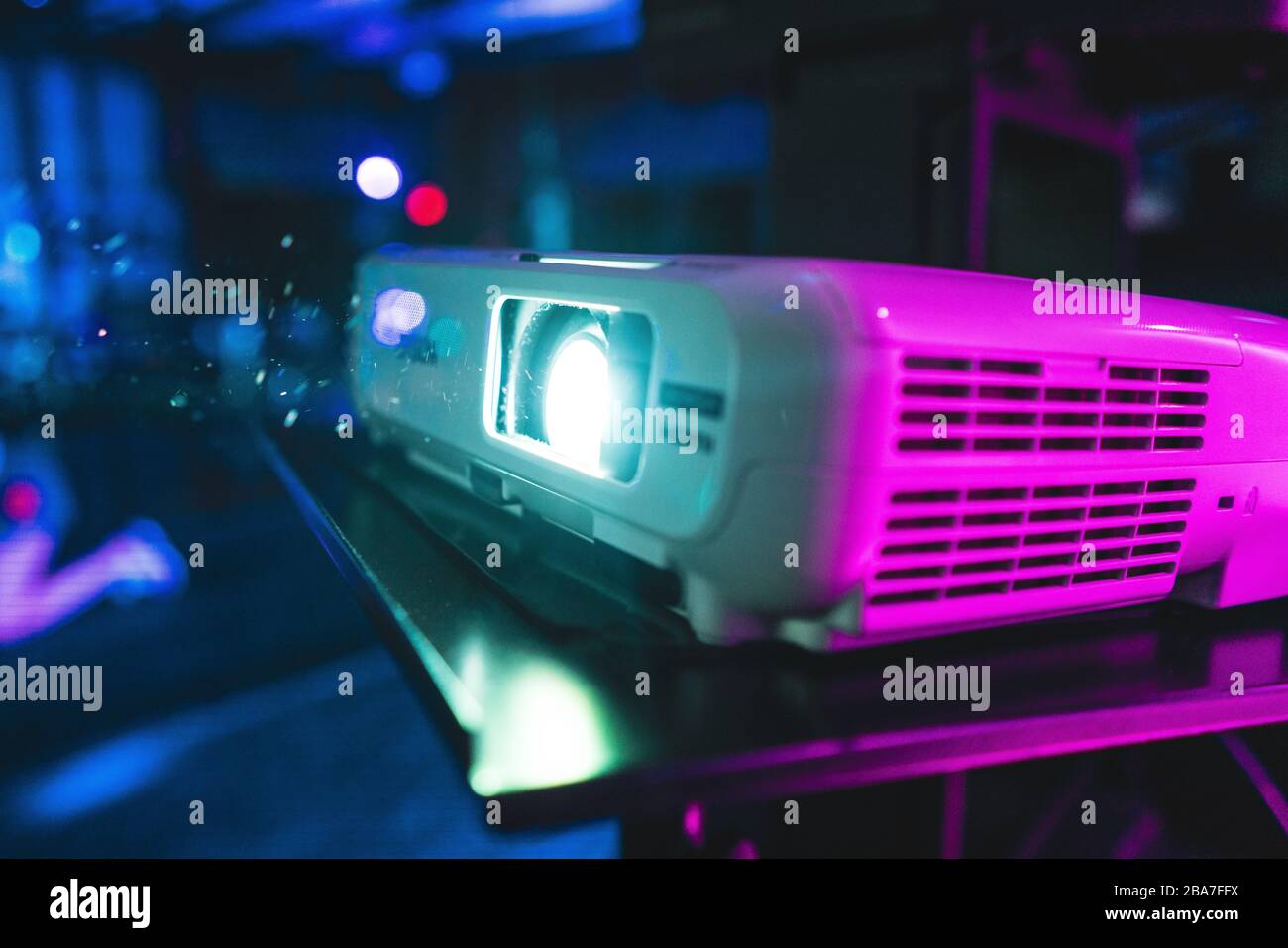 Closeup of a projector under the colorful lights with a blurry ...