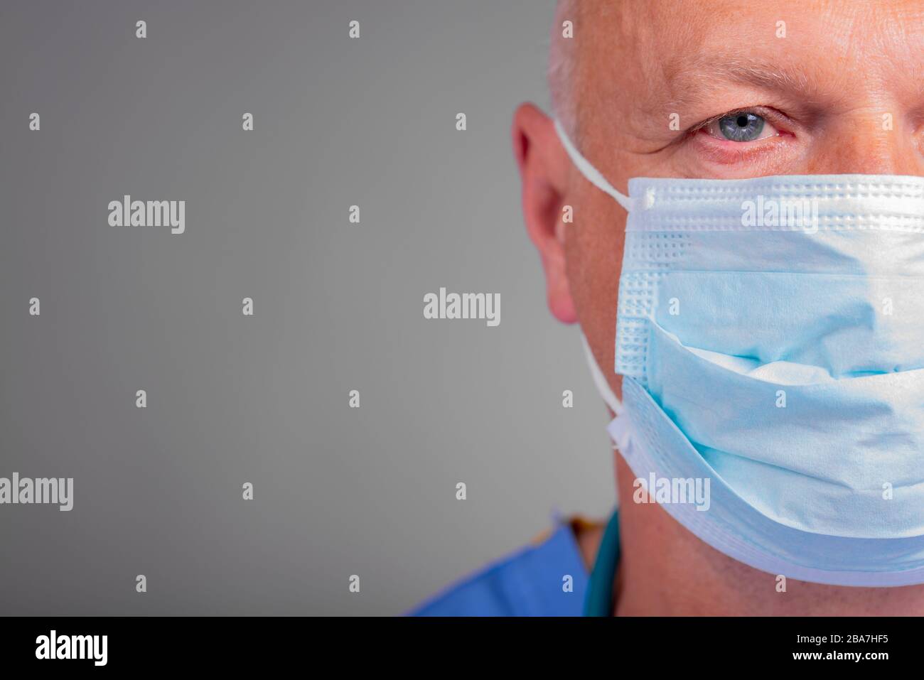 Close up, half face portrait of a caucasian hospital doctor in blue ...