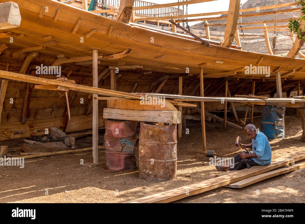 Traditional craftsmen work in a traditional Dhow boat building yard in ...