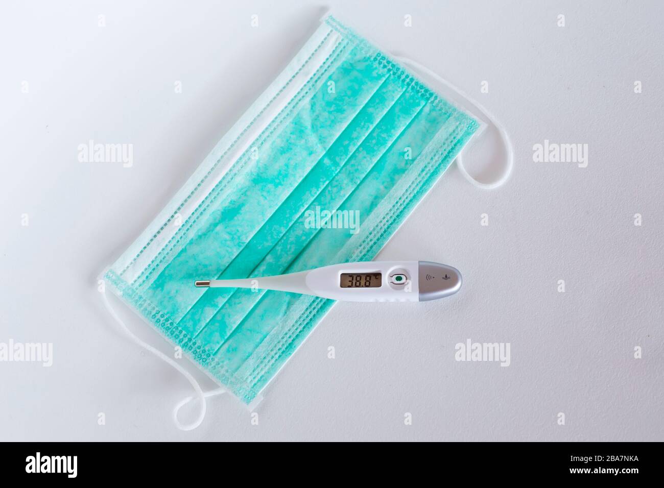 Surgical ear-loop mask and thermometer on the table Stock Photo - Alamy