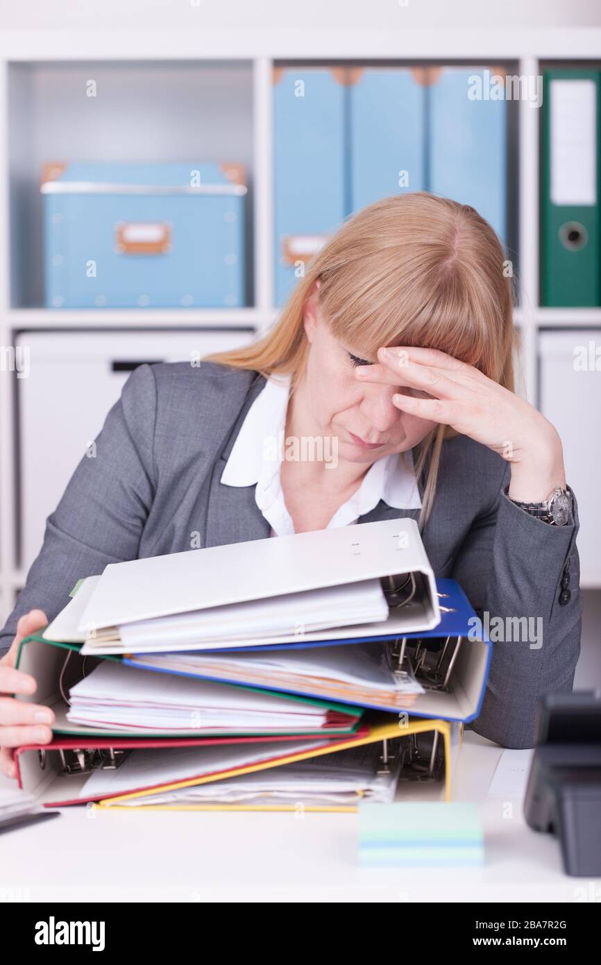Overwhelmed woman at the office. Overworked, burnout and stress concept ...