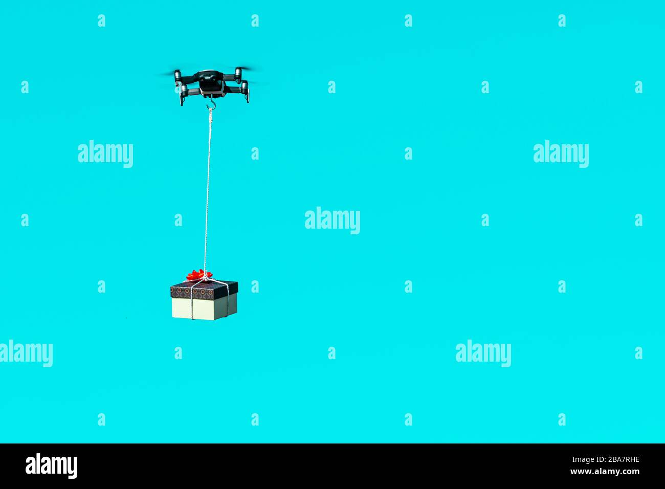multicopter drone flying with a gift box isolated on a light blue ...