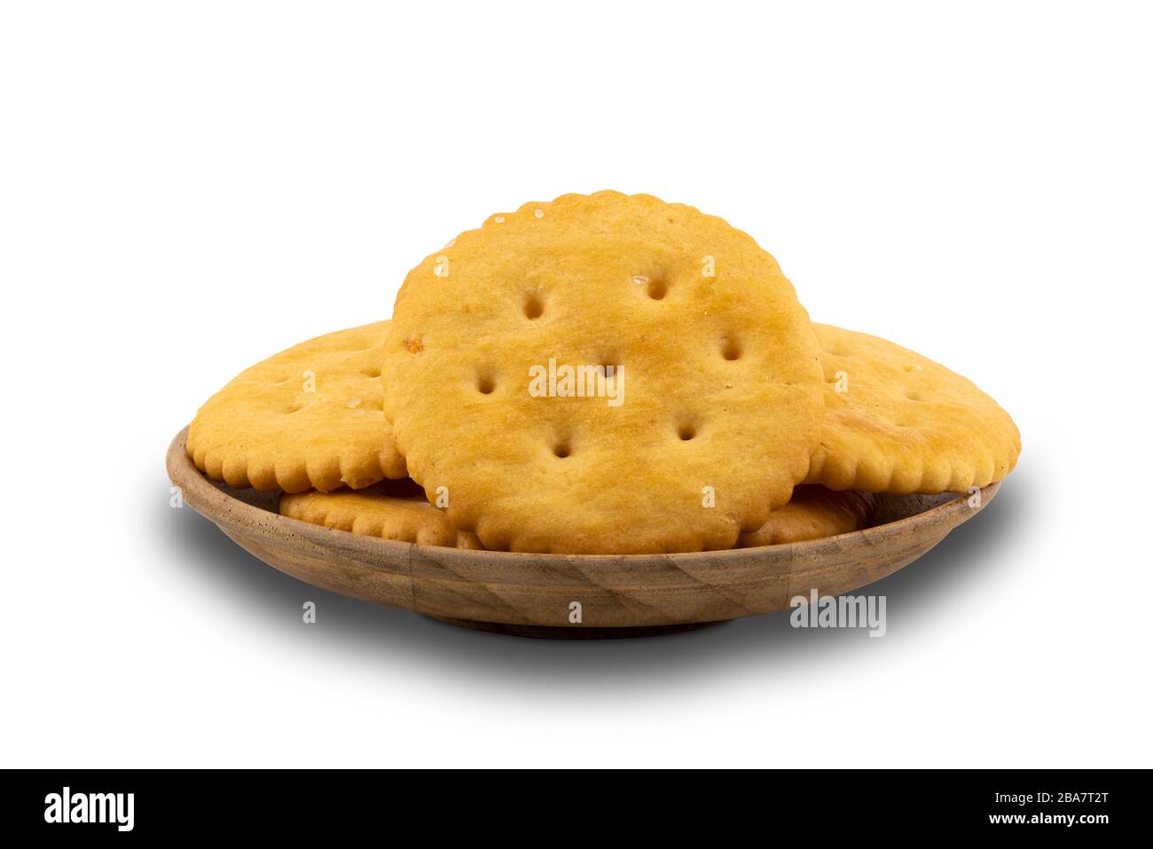 Pile of crunchy round crackers in wooden plate on white background with ...