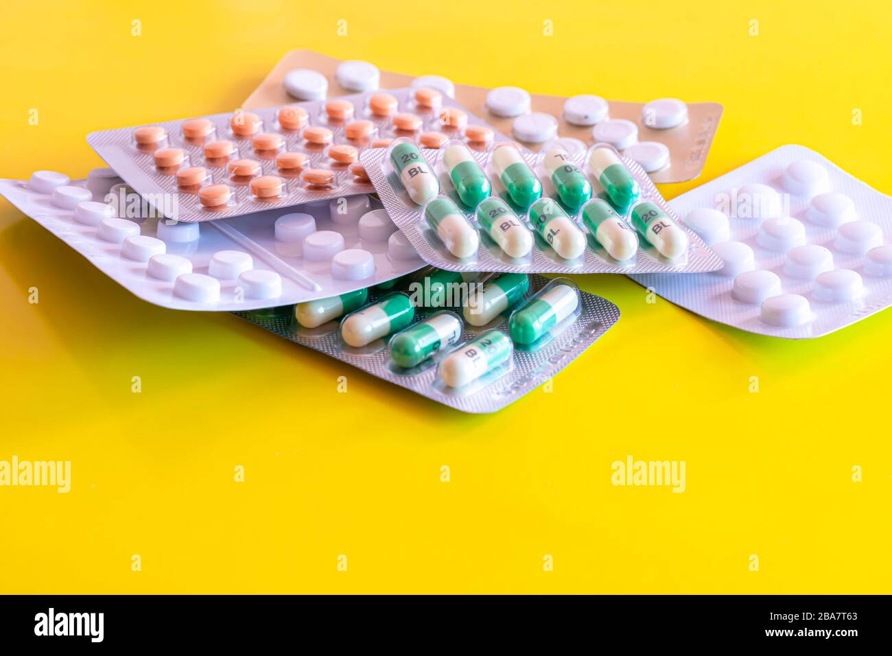 Six blisters of generic tablets yellow background.Pills in packages ...