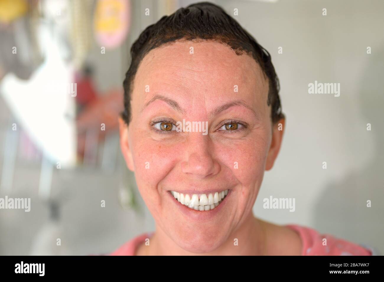 Cute charismatic woman with a cheeky grin and hair dye developing on ...