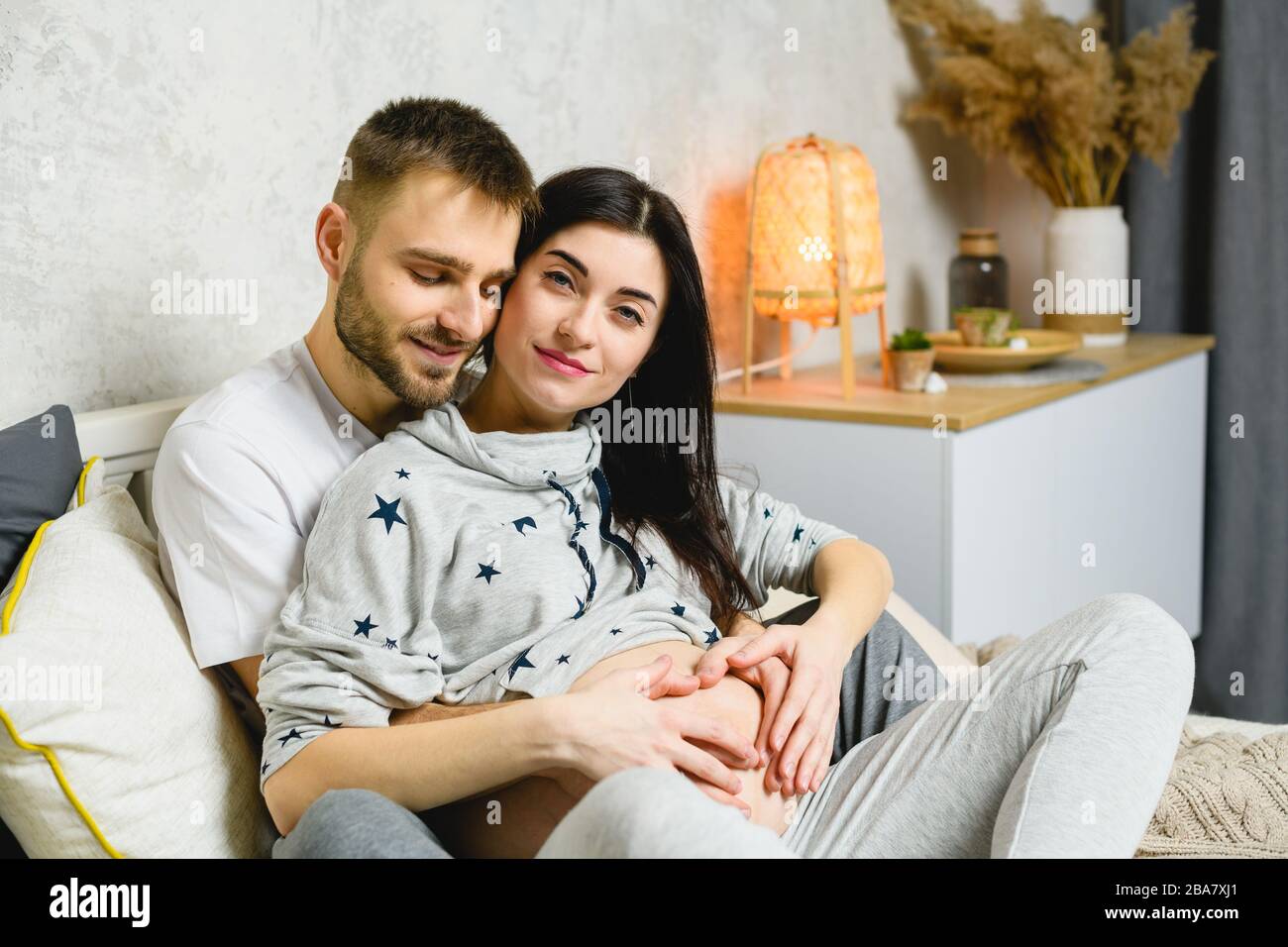 Pregnant couple husband wife cuddling hi-res stock photography and ...