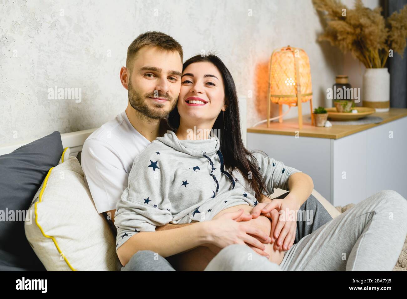 Happy young couple expecting baby at home. Pregant woman and her ...