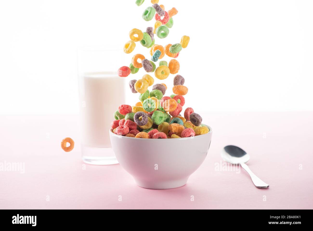 selective focus of bright multicolored breakfast cereal falling in bowl ...
