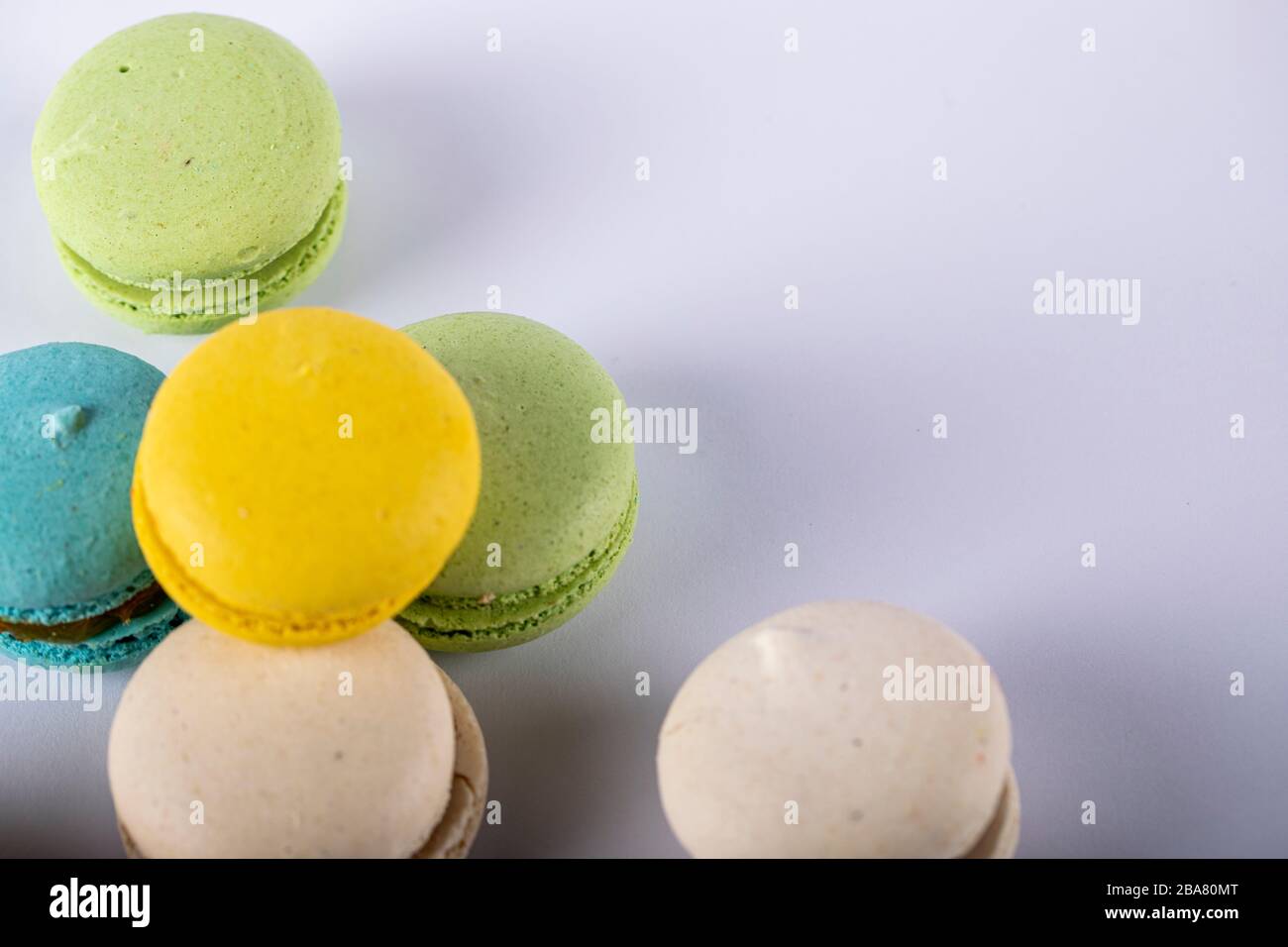 Colorful macarons isolated on white on the left corner Stock Photo - Alamy