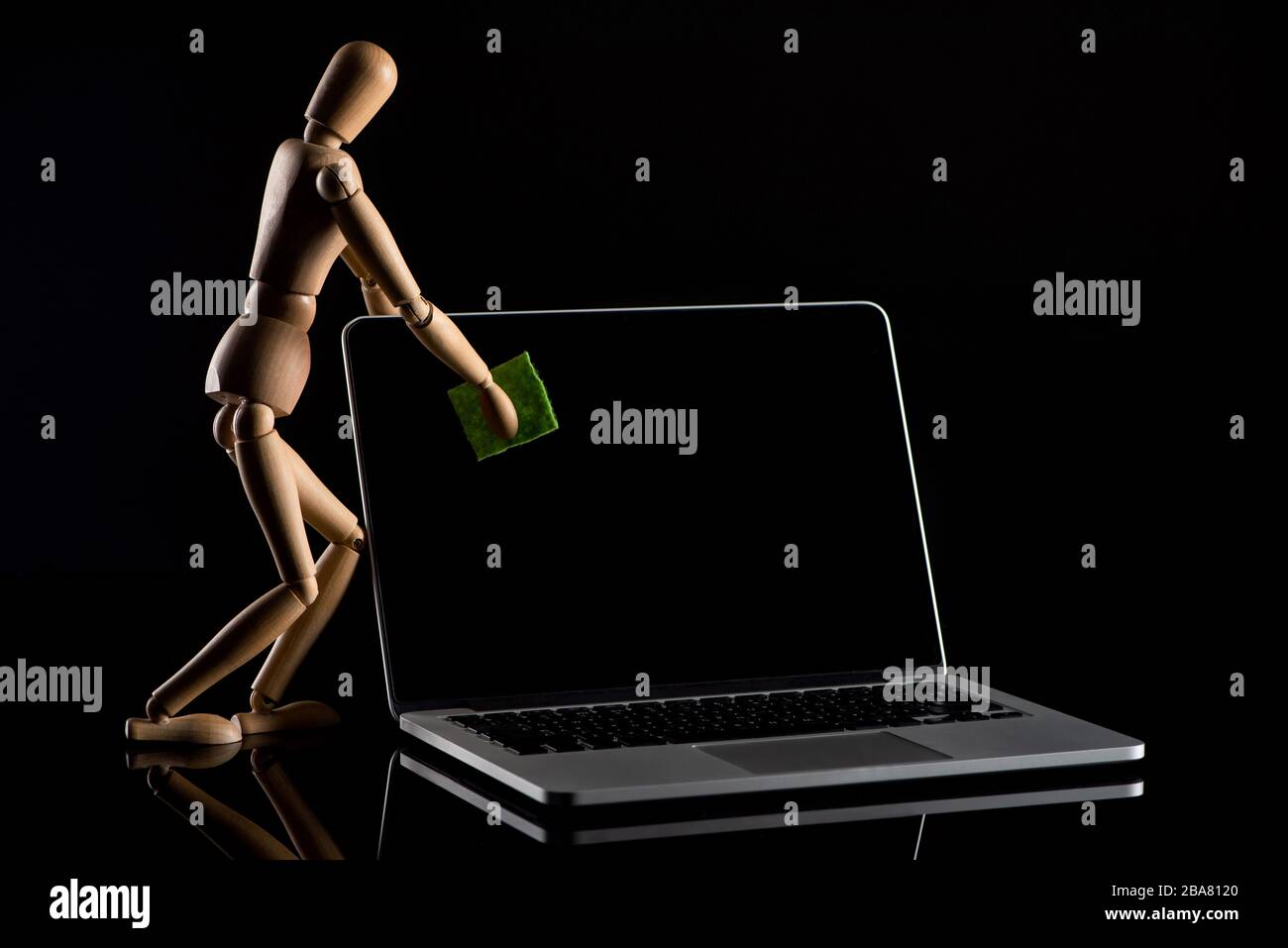 Wooden puppet imitating dusting laptop on black background Stock Photo ...