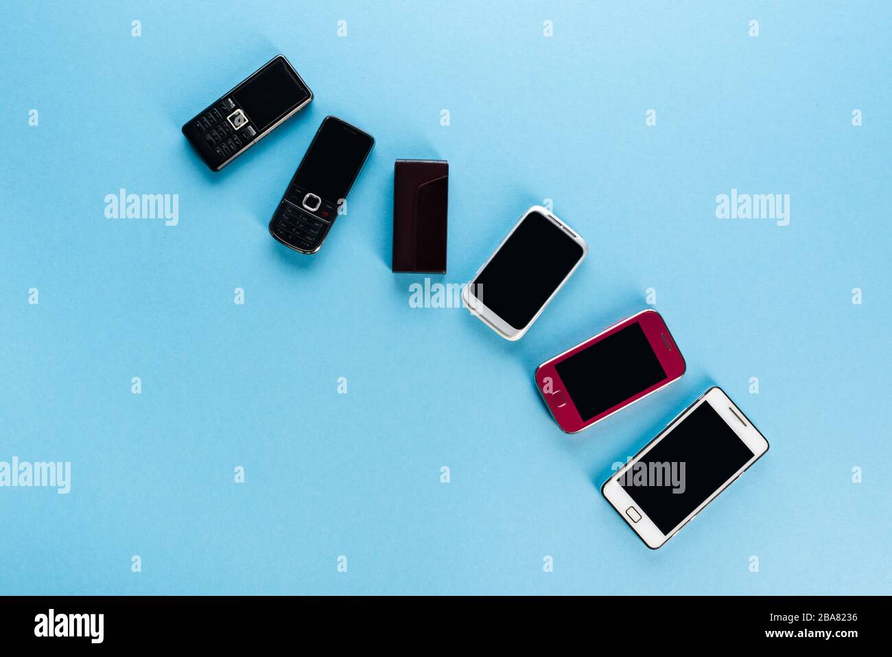top view of vintage mobile phones and modern smartphones on blue ...